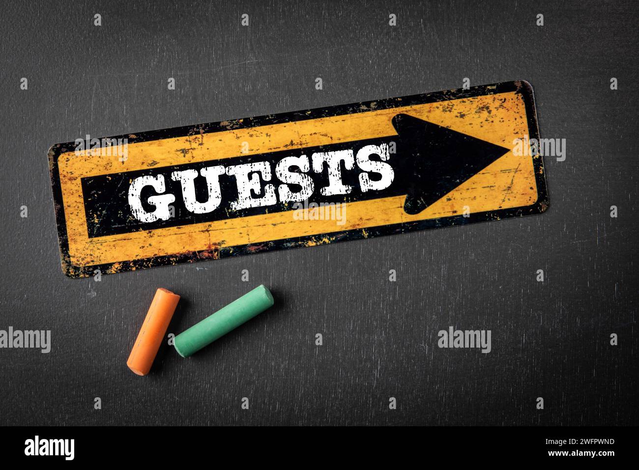 GUESTS. Direction arrow with text on a dark chalkboard background Stock ...