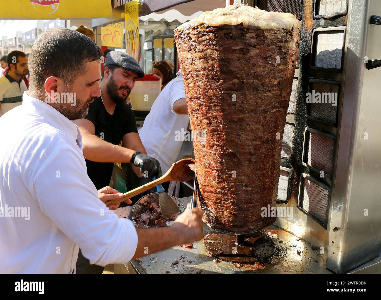 ADANA, TURKEY-OCTOBER 09,2022:Unidentified Guy cutting Beef Doner Kebab ...