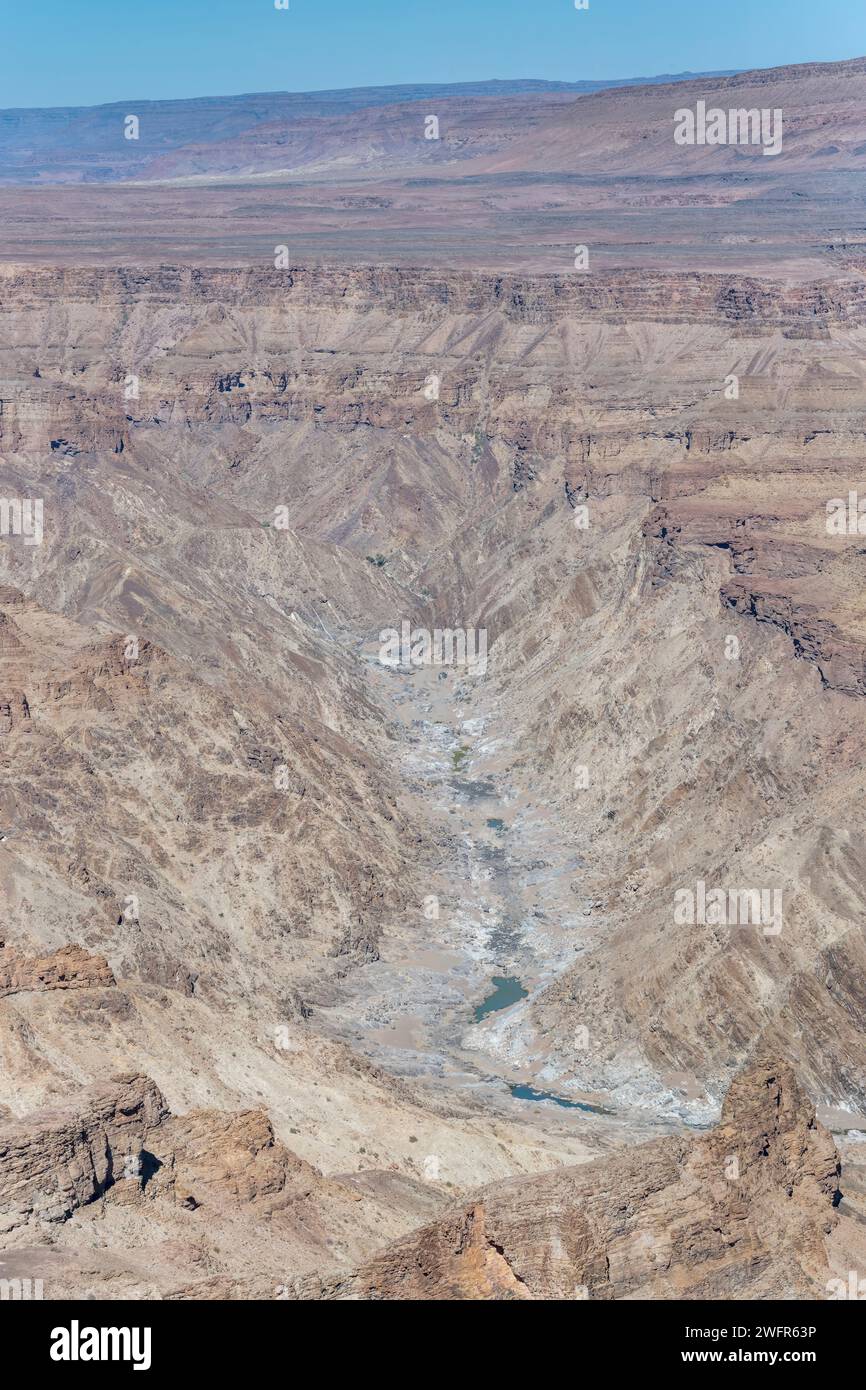 aerial landscape with steep slopes and little water in dry riverbed ...