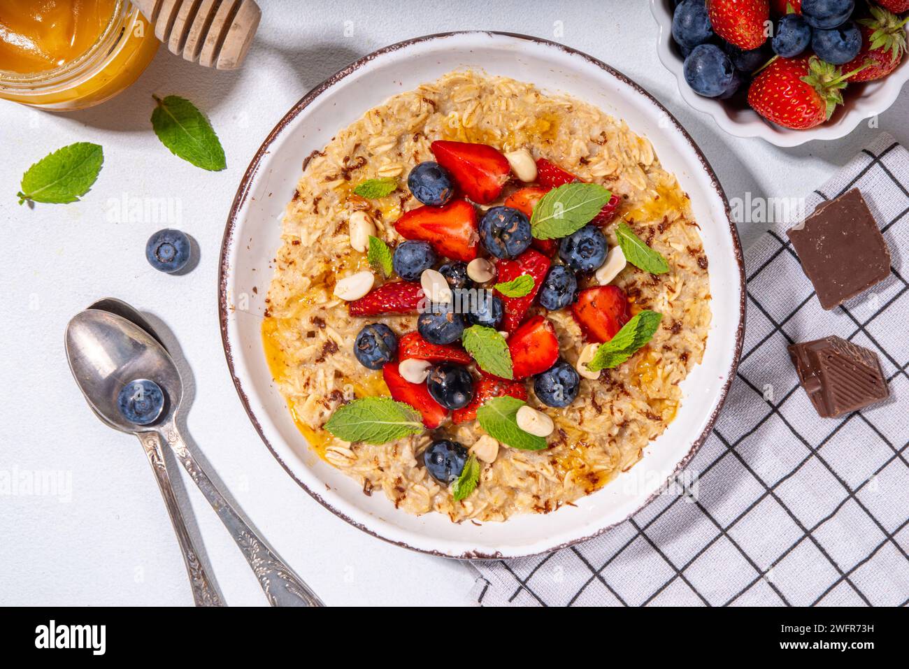 Summer breakfast oatmeal with strawberry, blueberry, nuts, chocolate ...