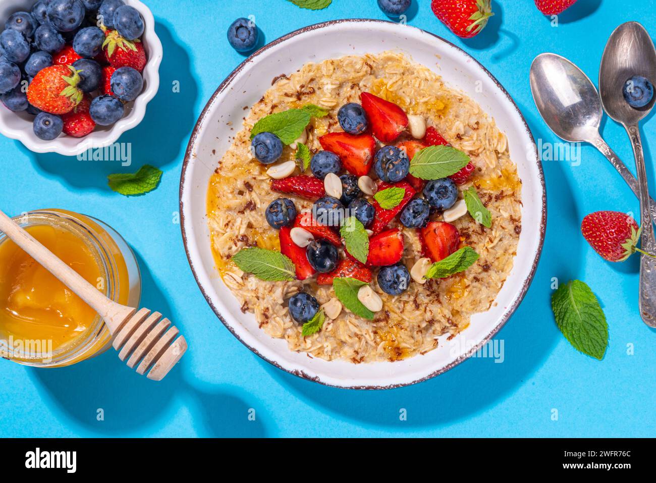 Summer breakfast oatmeal with strawberry, blueberry, nuts, chocolate ...