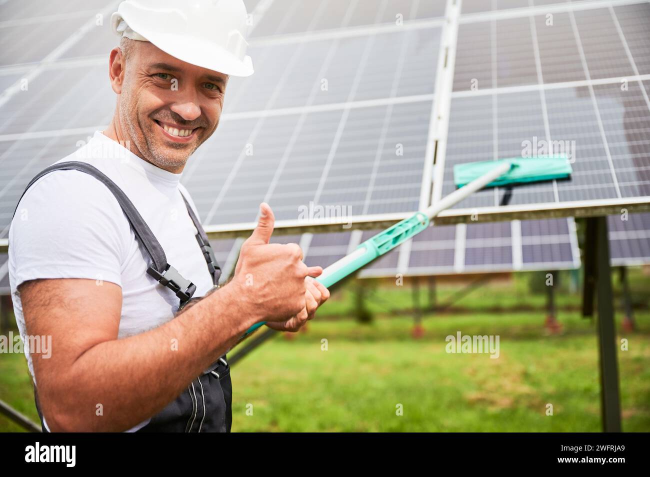 Professional worker showing his good job of cleaning solar panel ...
