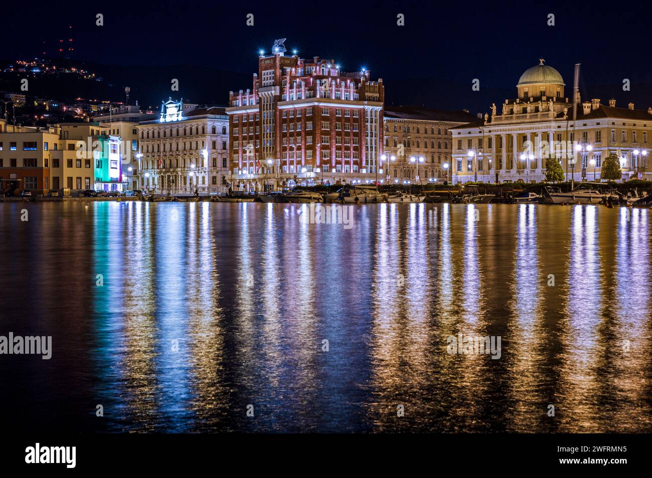 Dusk and night in Trieste. Between historic buildings and the sea Stock ...