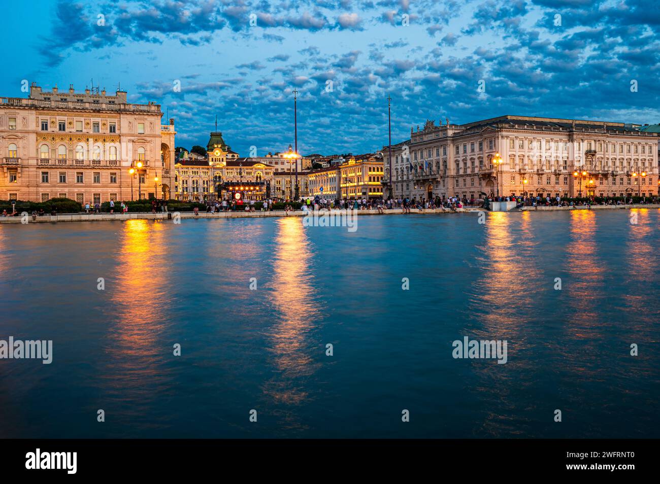 Dusk and night in Trieste. Between historic buildings and the sea Stock ...