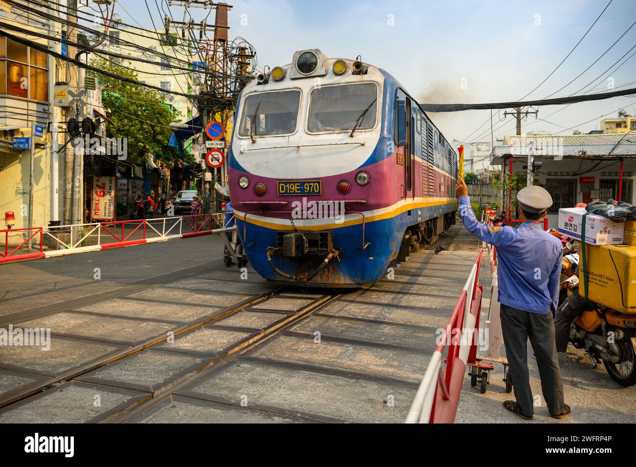 A Vietnamese railway train passing through a Level Crossing, Ho Chi ...