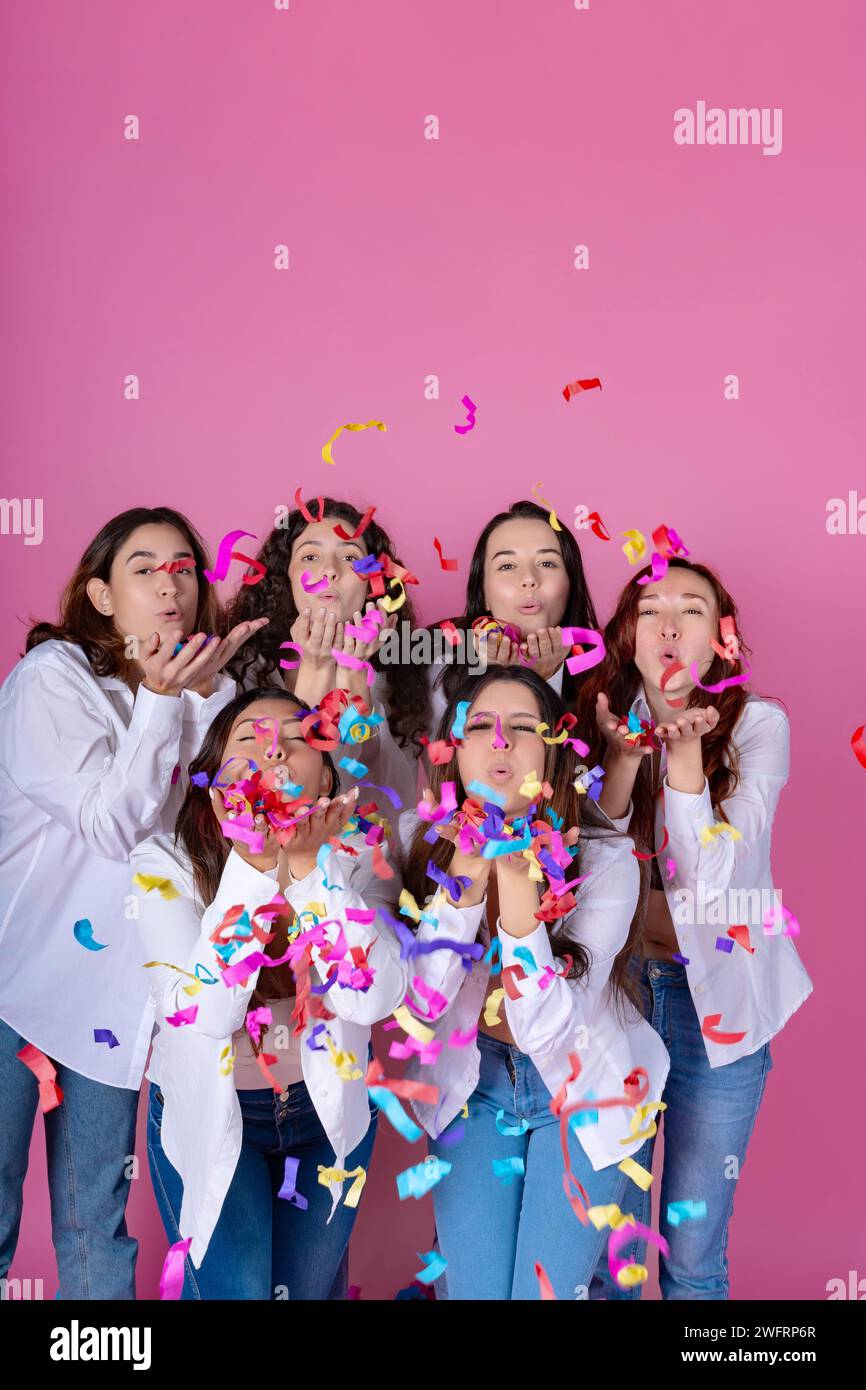 Group of girls in white shirts celebrating with a burst of confetti ...