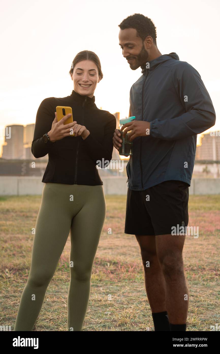 Young athletes using apps on the phone to keep track of their exercise ...