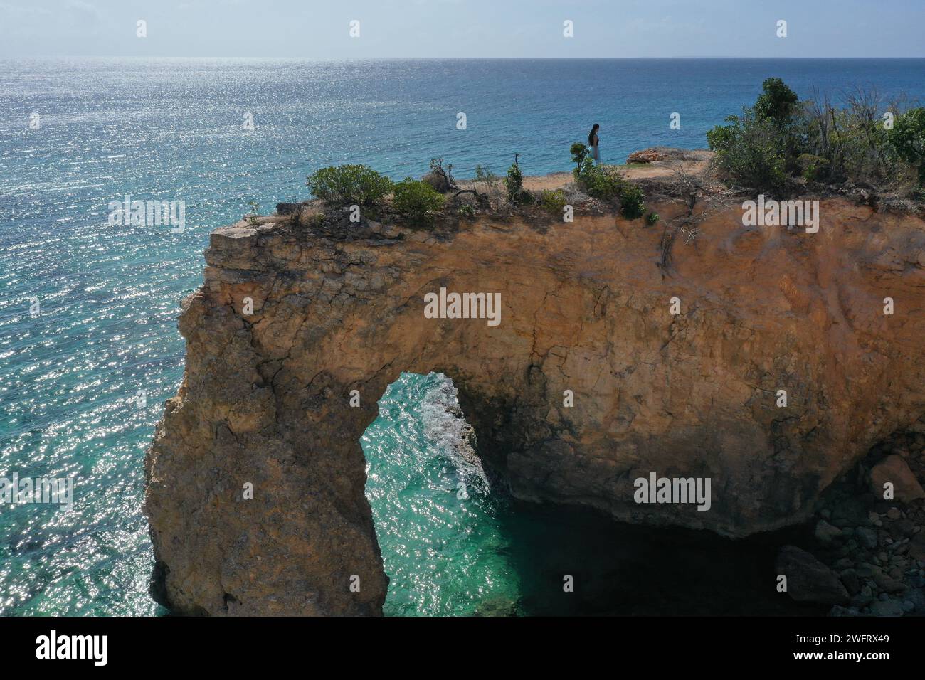 An areal view of The Anguilla Arch Cave by water's edge, nestled on ...