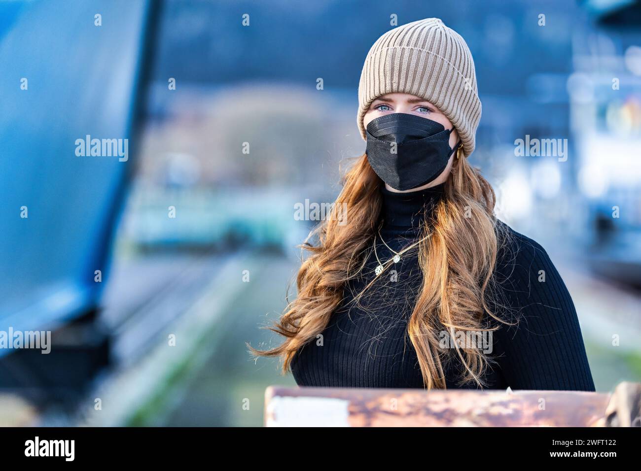 The picture shows a red -haired young woman, she wears an FFP 2 mask to ...