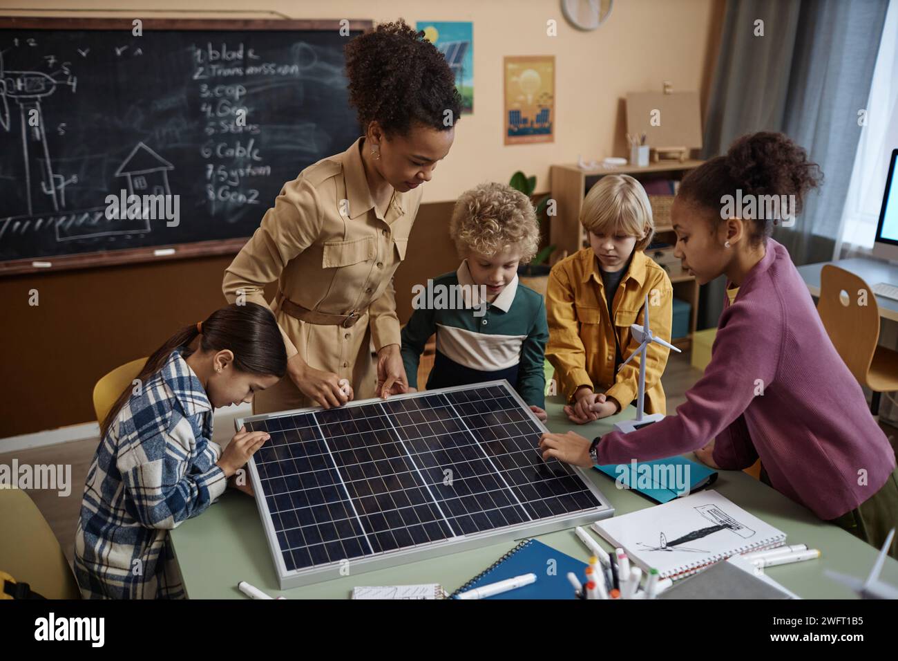 Multiethnic group of kids learning about renewable energy in school ...