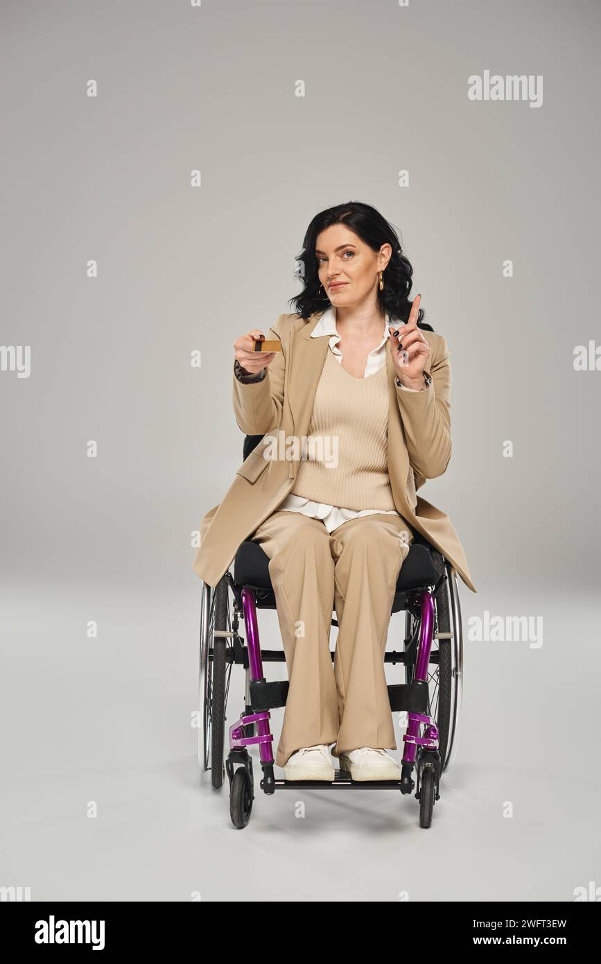 attractive disabled woman sitting in her wheelchair with credit card ...