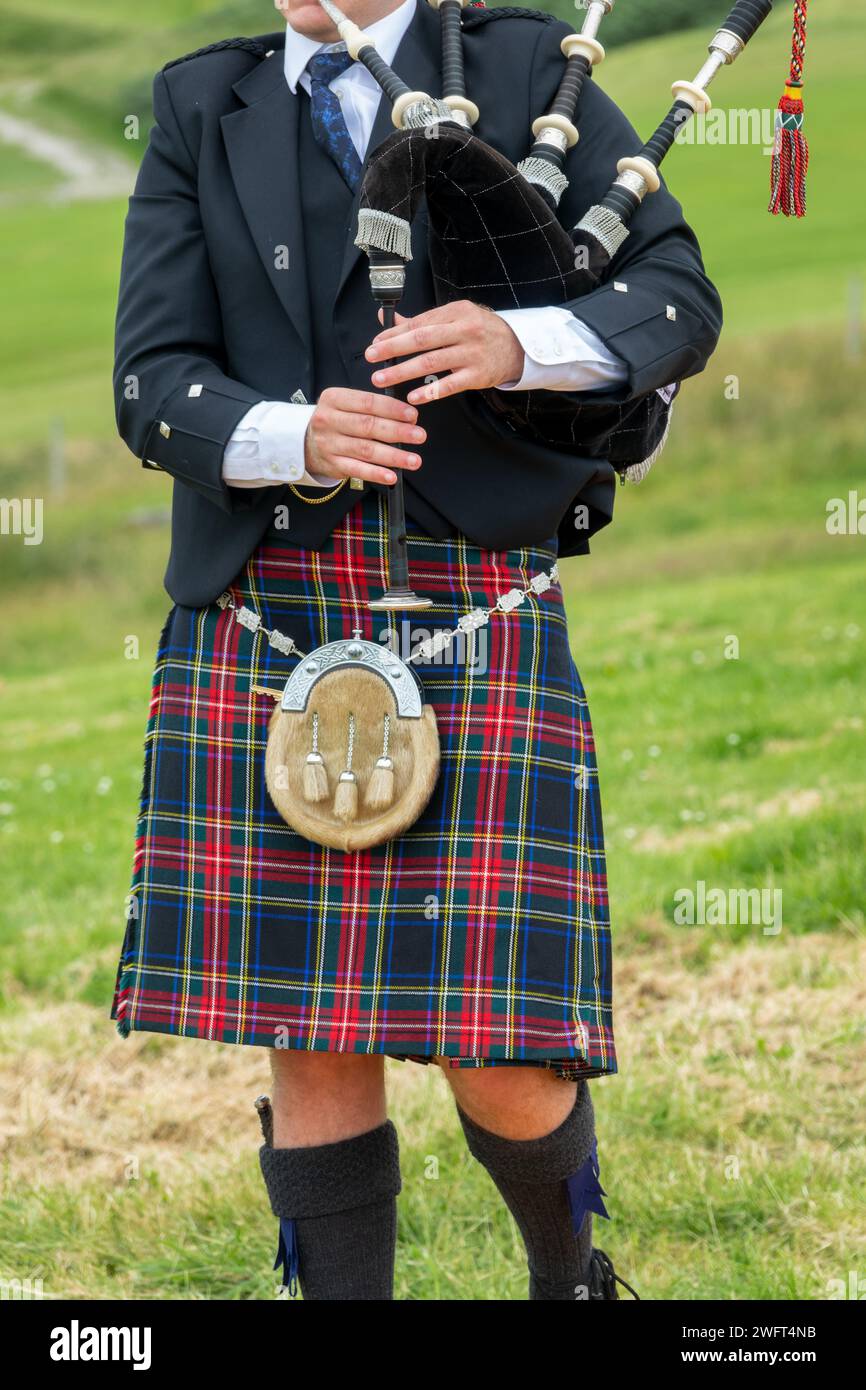 Close up of a Scottish bagpiper dressed in traditional kilt in the ...