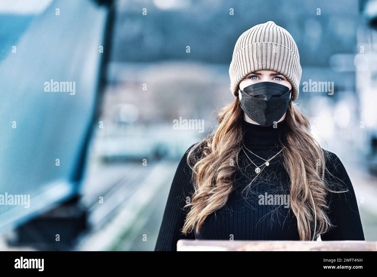 The picture shows a red -haired young woman, she wears an FFP 2 mask to ...