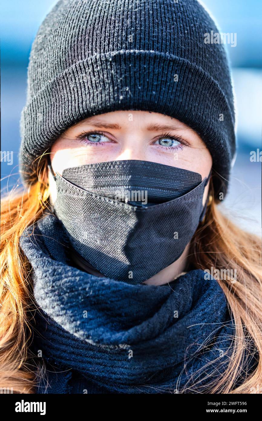 The picture shows a red -haired young woman, she wears an FFP 2 mask to ...