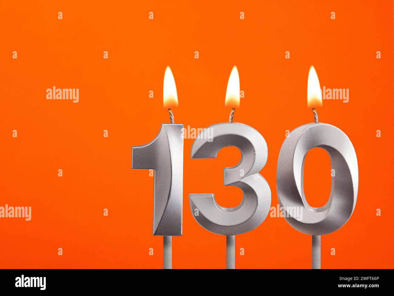 Candle number 130 - Birthday in orange background Stock Photo - Alamy