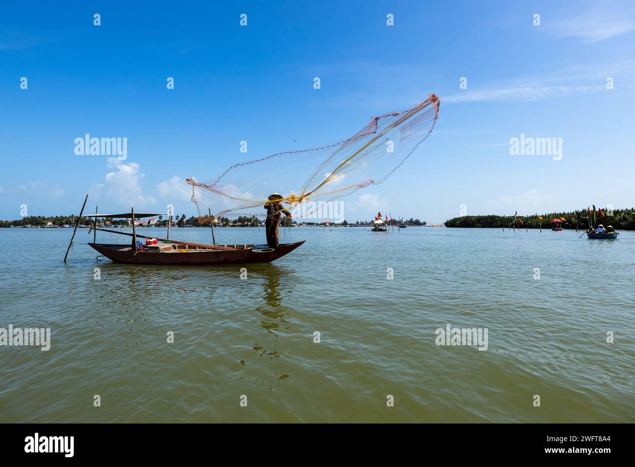 An old fisherman is throwing a net to catch fish Stock Photo - Alamy