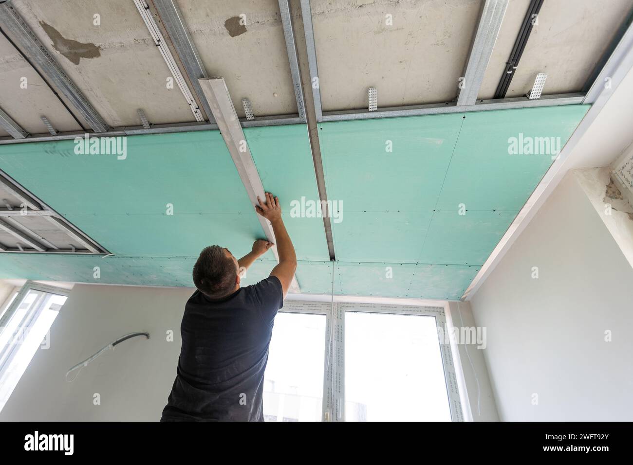 Drywall Installers. Men holding a gypsum board figured cut Stock Photo ...