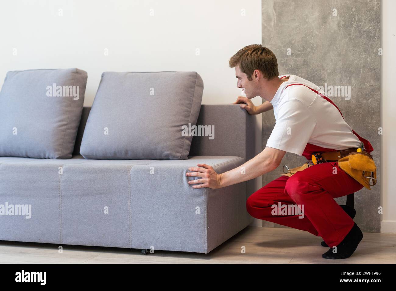 young worker lift up heavy sofa. Young men from moving company and ...