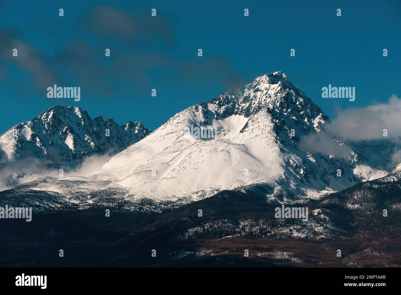 The beautiful view of snow-capped mountains against the blue sky ...