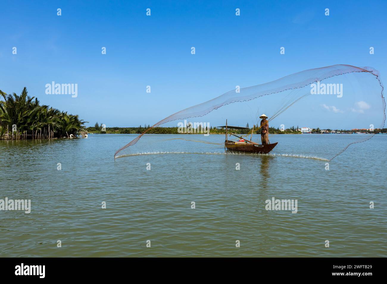An old fisherman is throwing a net to catch fish Stock Photo - Alamy