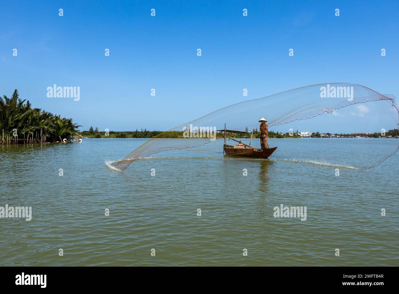 An old fisherman is throwing a net to catch fish Stock Photo - Alamy