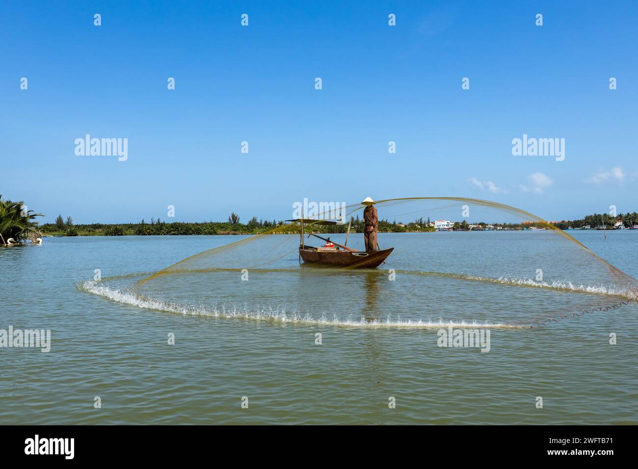 An old fisherman is throwing a net to catch fish Stock Photo - Alamy