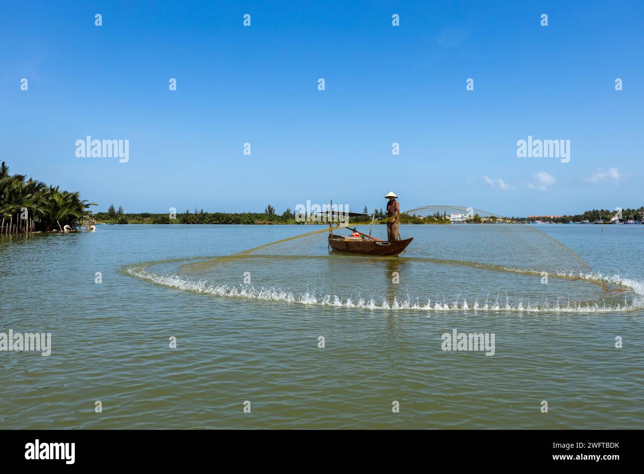 An old fisherman is throwing a net to catch fish Stock Photo - Alamy