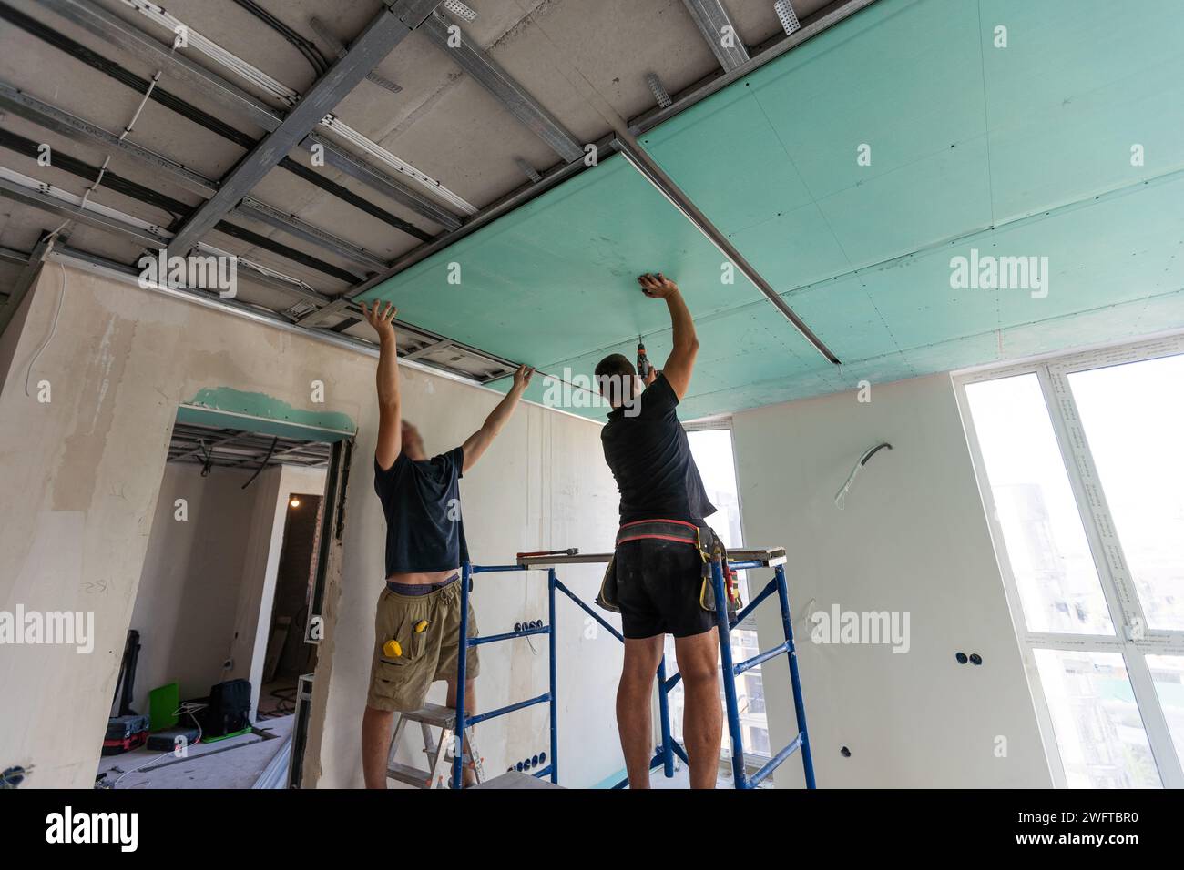 Construction worker ceiling work installation Stock Photo - Alamy