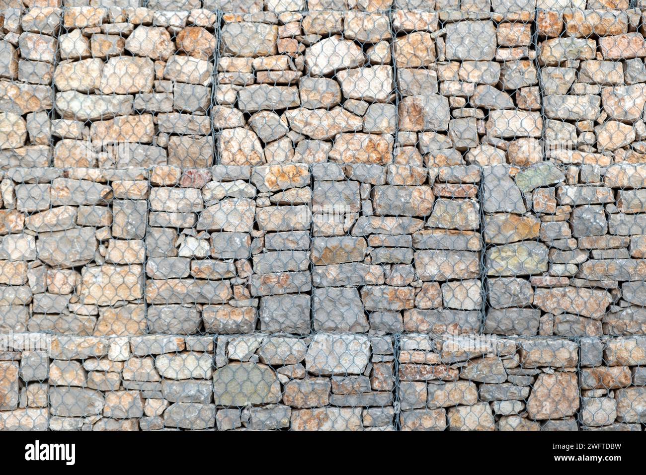 Stonewall behind wire mesh background texture. Metal lattice for ...
