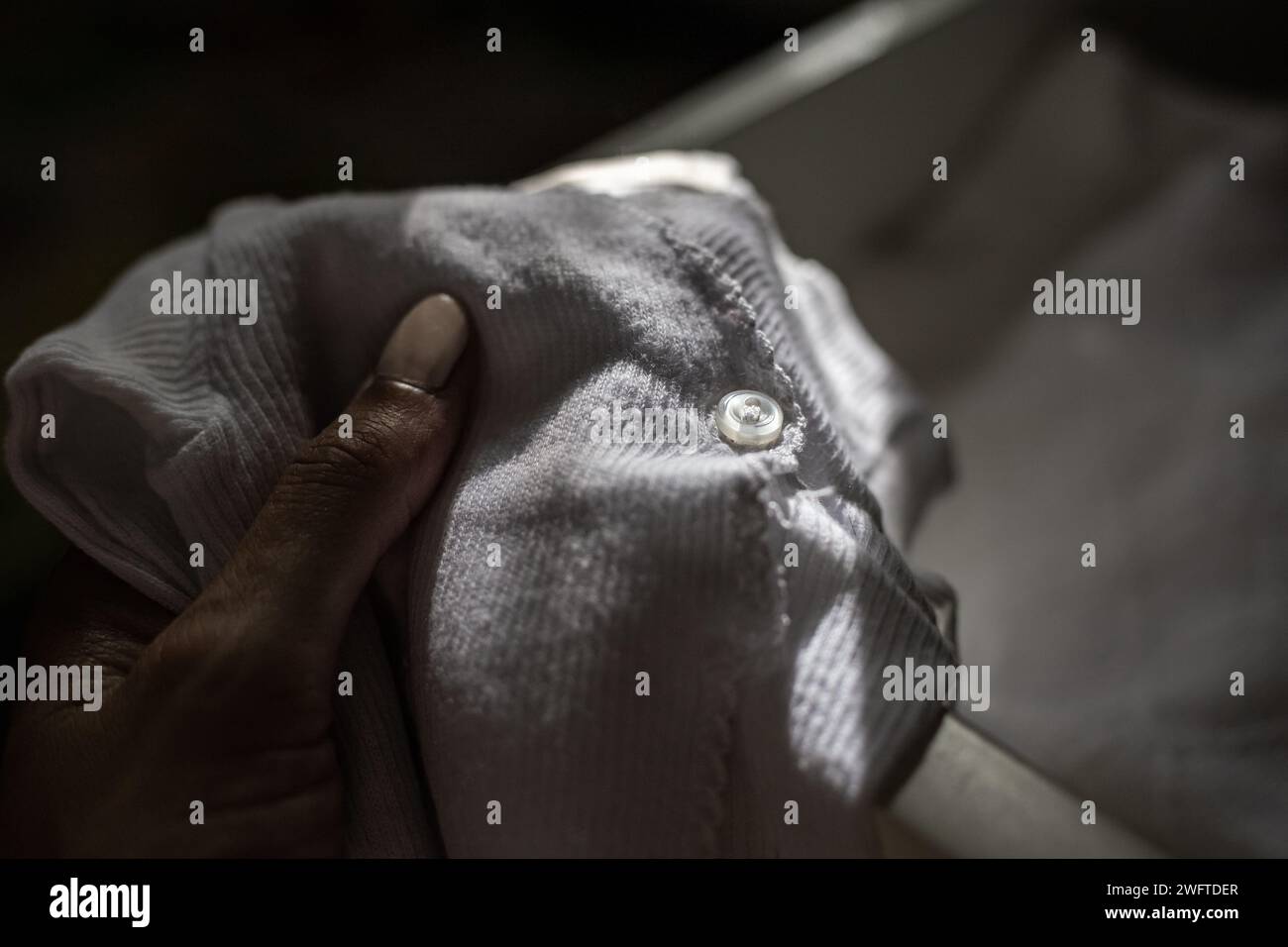 Person placing shirt on clothes rack Stock Photo - Alamy