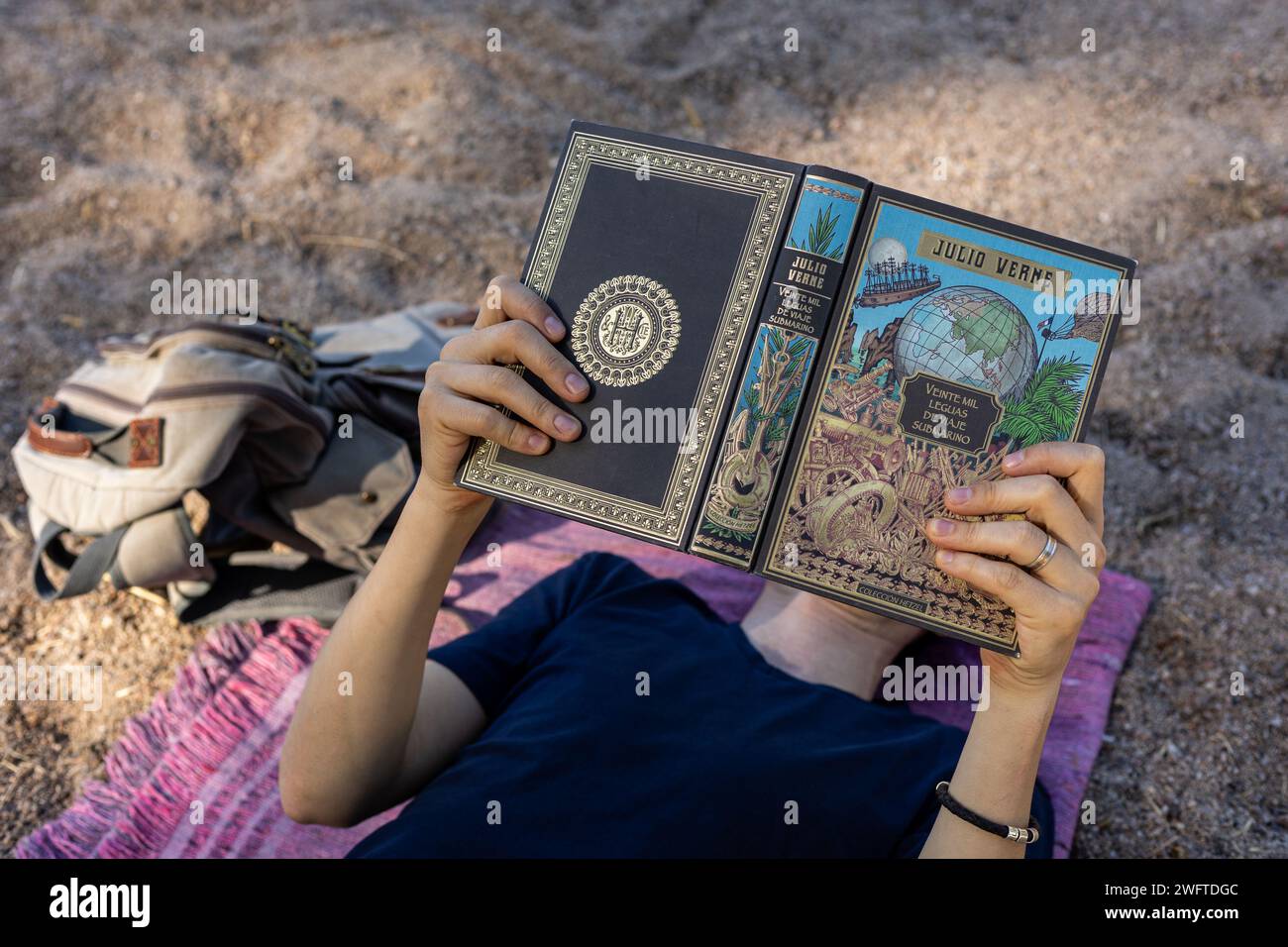 top of her face, covering her eyes, and she appears to be immersed in ...