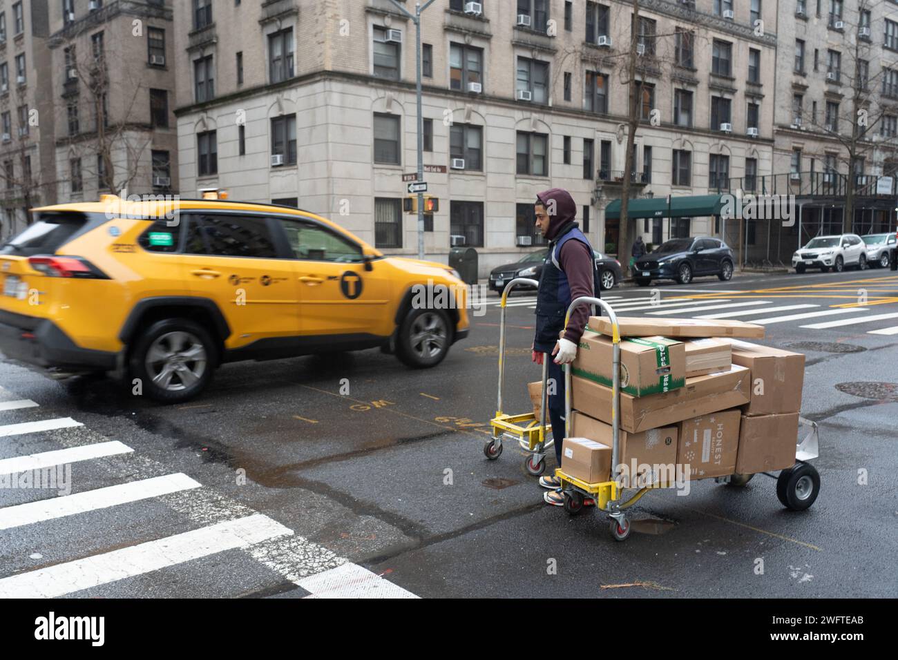 A delivery worker with packages on the Upper West side of New York City ...