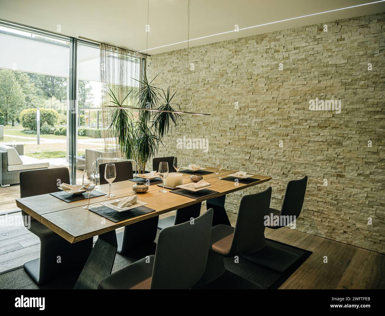 Luxurious dining room interior with textured stone wall and ...