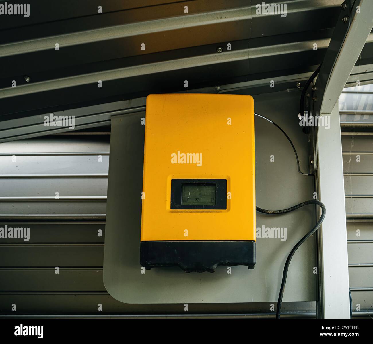Industrial yellow solar power inverter installed on a metal wall Stock ...
