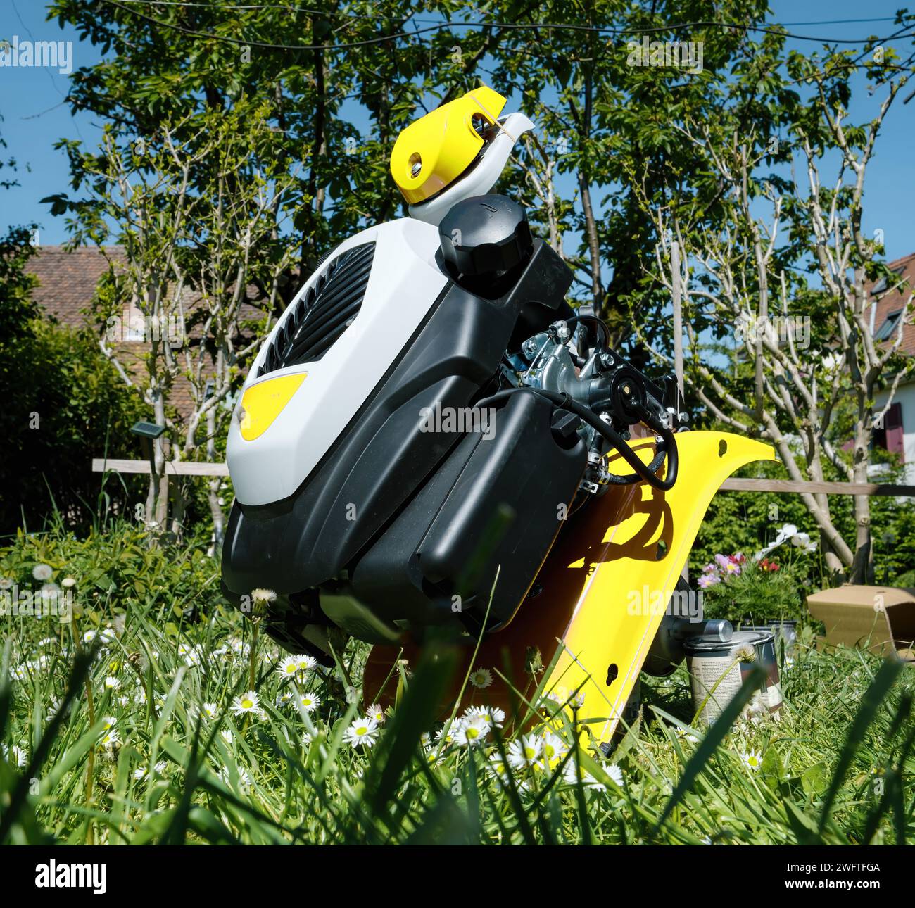 The process of assembling a tiller unfolds in a spacious garden, with a ...