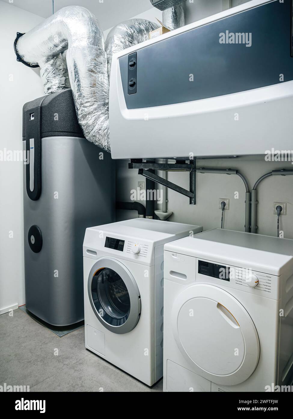 Residential laundry room equipped with modern washing machine, dryer ...