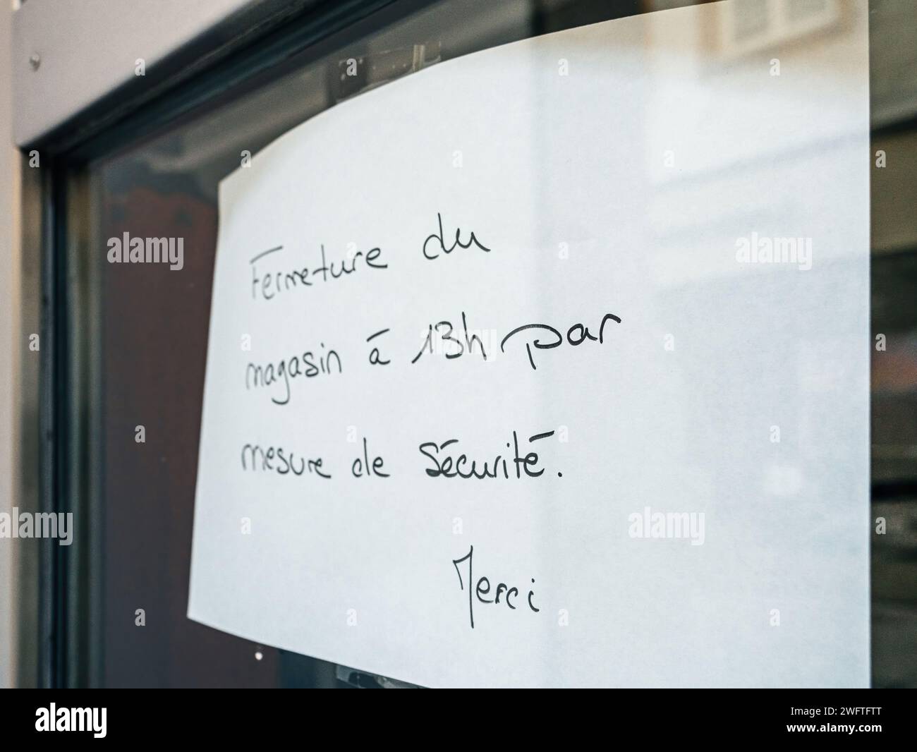 Handwritten sign in French indicating store closure for security ...