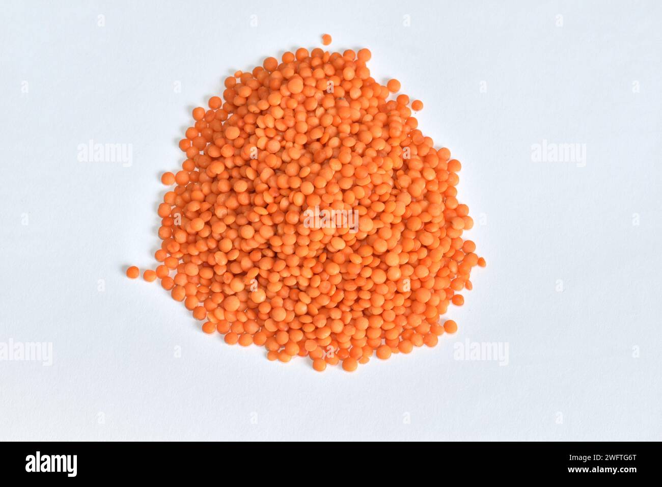 A hill of red lentil grains lies on a white background Stock Photo - Alamy