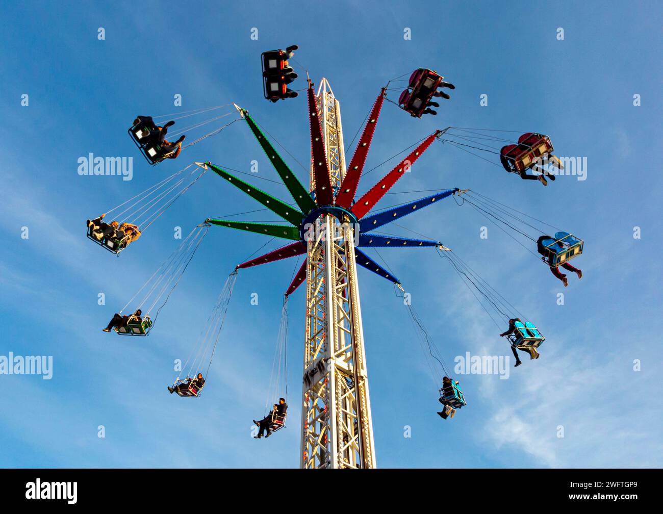 Swing carousel fairground ride with blue sky behind operating in Leeds ...