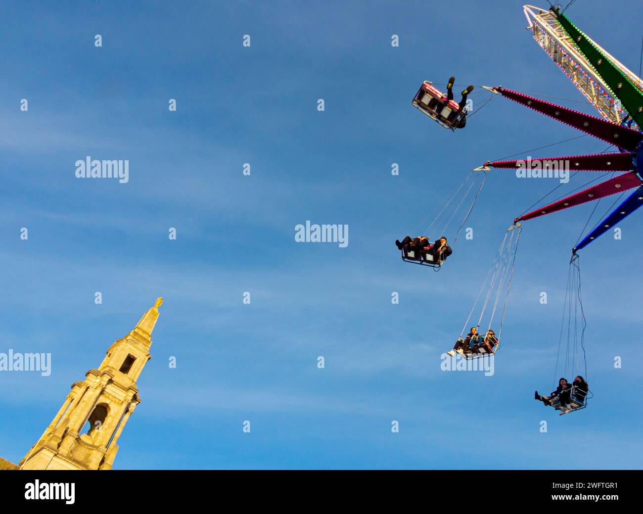 Swing carousel fairground ride with blue sky behind operating in Leeds ...