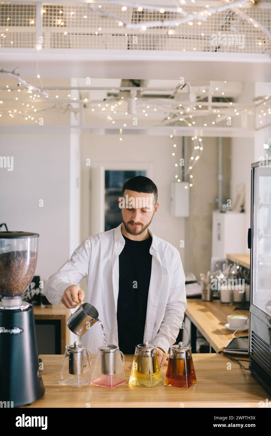 A young barista man prepares delicious teas in a modern cafe Stock ...
