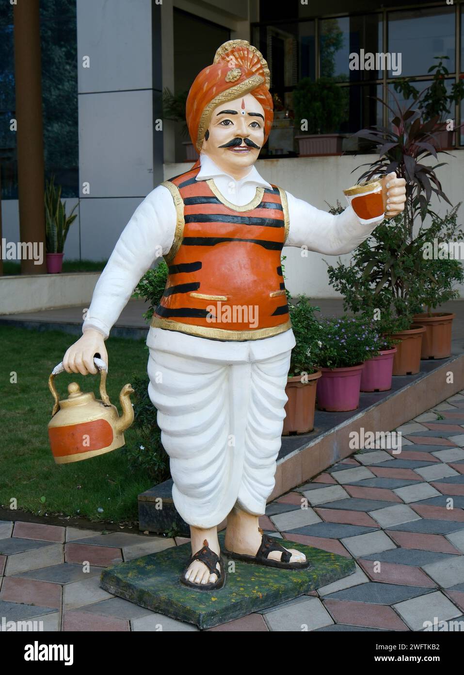 Statue depicting a tea vendor in a colourful garb and turban with a tea ...