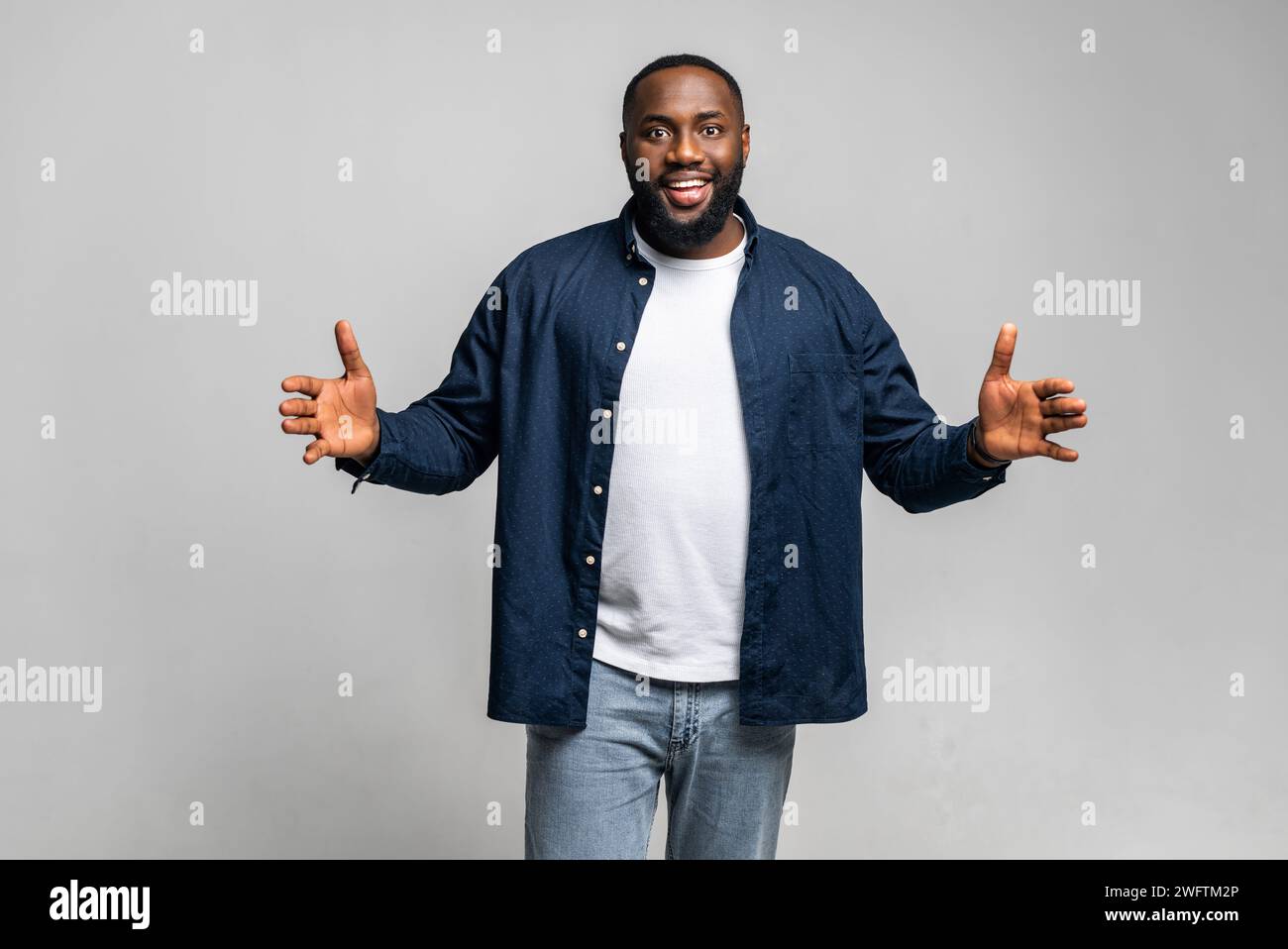 A cheerful African-American man stands with arms outstretched ...