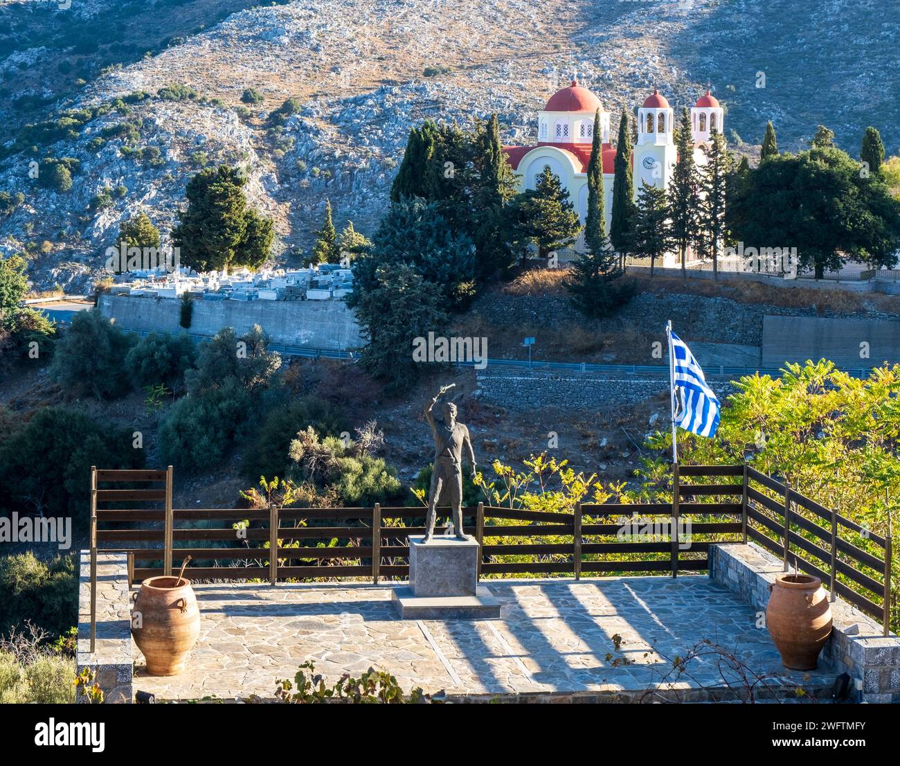 Statue of Cretan resistance fighter near church in mountain village of Gonies, central Crete ...