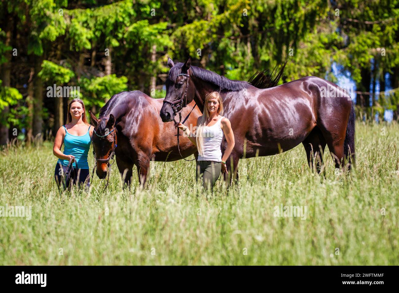 The picture shows two young women in light summer riding clothes with ...