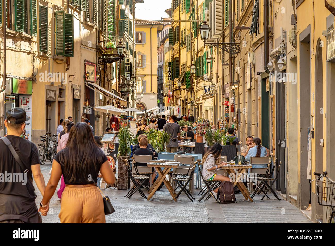 People walking along Via Faenza ,a lively street lined with many ...