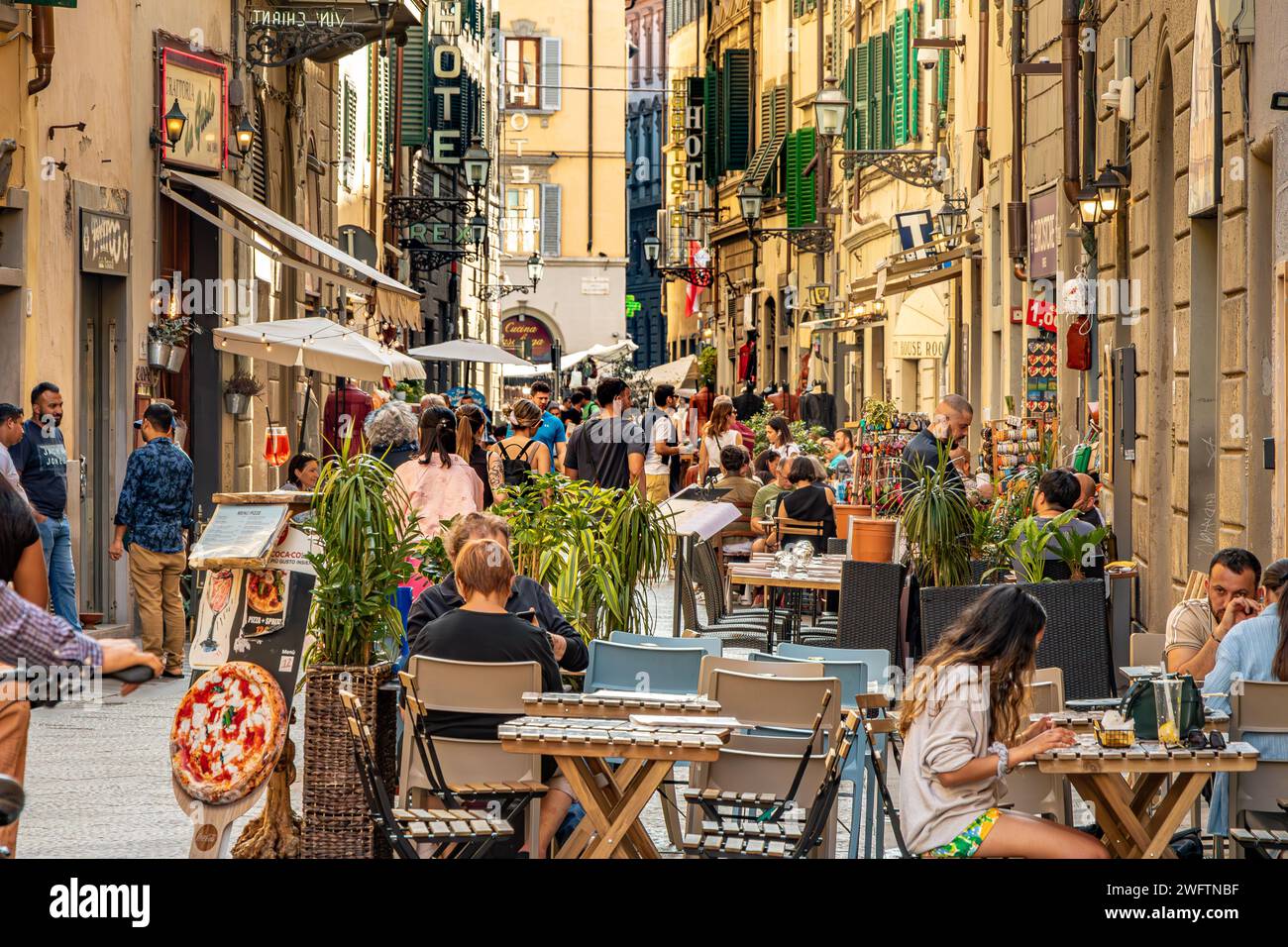 People walking along Via Faenza ,a lively street lined with many ...