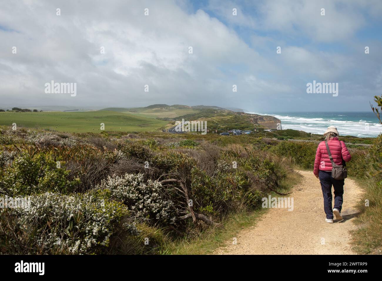 A tourist wanders on a path in Port Campbell National Park, Victoria ...