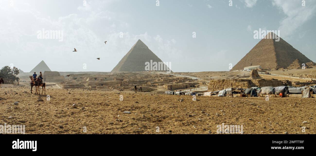 People riding horses near the majestic pyramids of Egypt Stock Photo ...