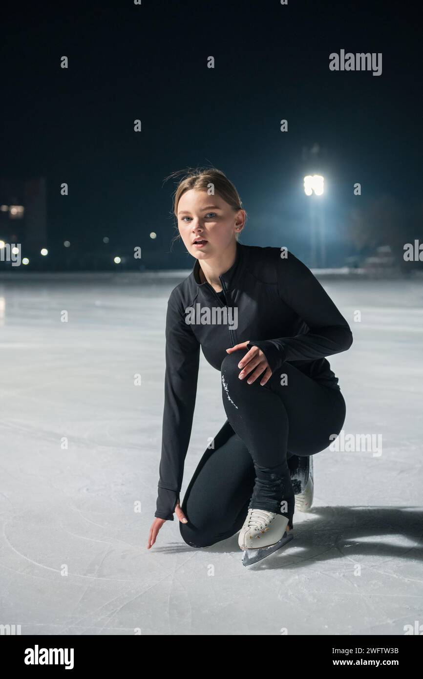 Beautiful young woman ice skating and performing short program over ...